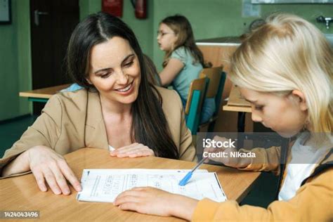 초등학교 교사가 책상에서 수업에서 여학생에게 설명하는 30 34세에 대한 스톡 사진 및 기타 이미지 30 34세 8 9 살 개발 Istock