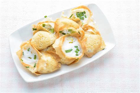 카놈 크록 또는 코코넛 라이스 팬케이크는 고대 태국 디저트 중 하나입니다 쌀가루 설탕 코코넛 밀크를 섞어 반죽을 만듭니다 0명에