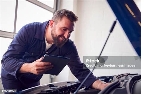 차고에서 남성 정비사 디지털 태블릿에 진단 소프트웨어를 사용하여 자동차 엔진을 서비스합니다 남자에 대한 스톡 사진 및 기타 이미지 Istock