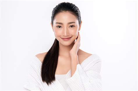 아름다운 젊은 아시아 여자는 흰색 배경 뷰티 화장품과 얼굴 치료 개념에 고립 된 신선한 건강한 피부로 그녀의 깨끗한 얼굴을 만지고 있습니다 건강한 생활방식에 대한 스톡 사진