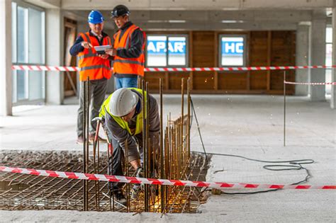 철망을 자르는 건설 노동자 두 남자가 디지털 태블릿을 배경으로 바라보는 동안 건설 산업에 대한 스톡 사진 및 기타 이미지