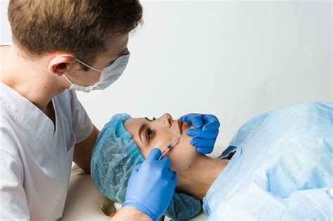 매력적인 소녀를위한 입술 확대 주사 성형 외과 의사는 의료 클리닉에서 입술에 주사를 않습니다 화장품 젊어지게 하는 얼굴 트리트먼트 광고를 위한 빈 공간 2명에 대한 스톡