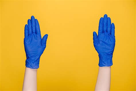 의료 용 보호 파란색 장갑에 남성의 손을 가까이 스튜디오에서 노란색 벽에 고립 음악 리듬 제스처에 그녀의 손가락을 스냅 광고를 위한 공간을 복사합니다 텍스트 또는 이미지장소