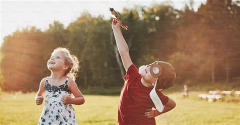 형제 자매가 함께 놀고 있습니다 야외에서 나무 비행기를 가지고 노는 두 아이 사진 Unsplash의 사진술 이미지