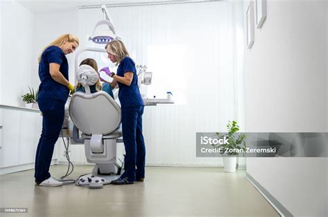 치과 진료소에서 일하는 조수가있는 여성 치과 의사가 환자의 치아를 검사합니다 25 29세에 대한 스톡 사진 및 기타 이미지 25 29세 35 39세 건강관리와 의술