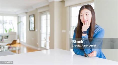 긴 머리를 입고 긴 머리를 가진 젊은 아름다운 아시아 여자 데님 재킷을 찾고 스트레스와 긴장 한 입에 손을 물고 손톱 불안 문제 T 셔츠에 대한 스톡 사진 및 기타 이미지