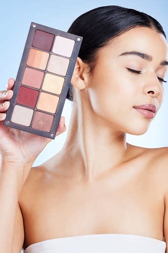 아름다움 아이섀도 그리고 화장품 파우더 파운데이션을 위한 파란색 배경에 화장을 한 여자 미용 살롱 미학 팔레트가 있는 소녀의