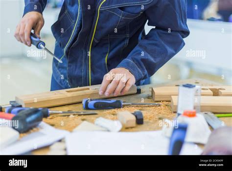 Professional Man Carpenter Using Chisel To Carve Wood On Rough