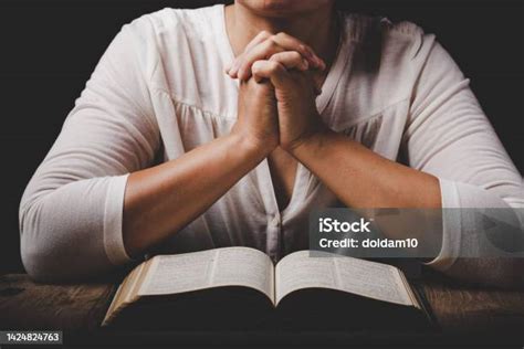 기독교 여성의 손을 거룩한 성경에 손을 대고 검은 배경을 가진 교회에서 하나님 께 감사하는 예배를하고 성인 여성 사람은 책 신앙 영성 및 종교에 대한 개념 40 49세에