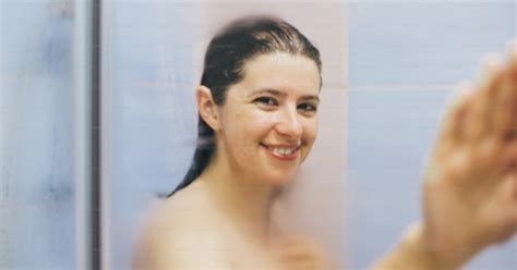 집이나 호텔 욕실에서 뜨거운 샤워를 하는 젊은 행복한 여자 아름다운 갈색 머리 소녀는 증기로 유리에 손을 잡고 샤워에서 시간을 즐깁니다 몸과 피부 위생 라이프 스타일