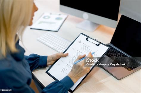 비즈니스 우먼 회사 이사 회사의 고용 전문가 현대 사무실의 책상에 앉아 채용 인터뷰를 진행하고 후보자의 이력서를 집중적으로 읽고