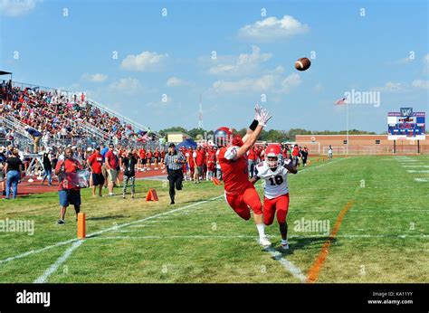 Receiver Gathering In A Touchdown Pass From His Quarterback After Beating An Opposing Defensive
