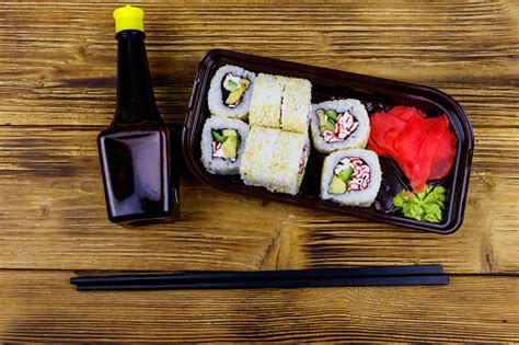 우라마키 초밥은 나무 테이블에 플라스틱 상자에 수리미와 롤 맨 위 보기입니다 플라스틱 용기에 초밥을 빼앗거나 배달하기 위한 초밥 간장에 대한 스톡 사진 및 기타 이미지