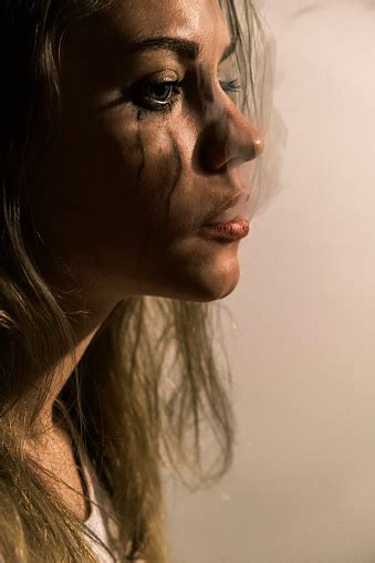 입에서 담배 연기를 풀어주는 우는 젊은 여성 인생에서 감정적 인 위기를 겪고있는 불행한 여성의 측면 모습의 초상화 가정의 심리적 신체적 폭력 세로 감정에 대한 스톡 사진 및