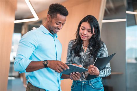 사무실 복도에서 디지털 태블릿을 사용하는 행복한 다인종 남성과 라틴 여성의 허리 업 샷 2명에 대한 스톡 사진 및 기타 이미지 2명 35 39세 가리키기 Istock