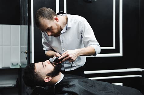마스터는 이발소에서 남자의 머리와 수염을 잘라 미용사는 젊은 남자를위한 헤어 스타일을 만든다 건강관리와 의술에 대한 스톡 사진 및 기타 이미지 Istock