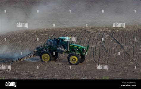Tractor Spraying Pesticides On Vegetable Field With Sprayer At Spring