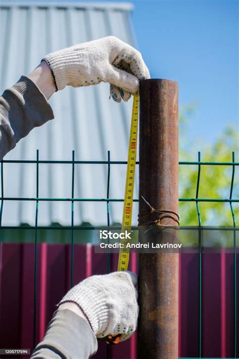 한 남자가 줄자로 금속 파이프를 측정합니다 울타리의 건설 Diy에 대한 스톡 사진 및 기타 이미지 Diy 가정 생활 건설