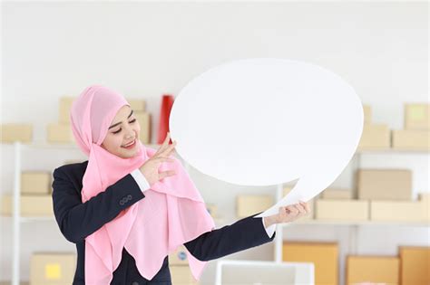 무슬림 파란색 정장을 입은 활동적인 아시아 여성이 온라인 패키지 상자 배달 배경으로 하얀 말풍선을 들고 있다 스타트업 중소기업 프리랜서 소녀는 행복한 얼굴로 집에서 일한다