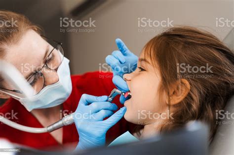 소아 소녀 치과 의사는 치과에서 전문적인 치아 청소를합니다 치과에서 아이의 치아에 대한 전문 위생 소아 치과 의사는 치과에서 어린이 환자를 검사하고 상담합니다 25 29세에