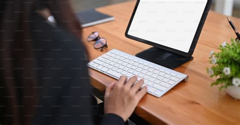 디지털 태블릿으로 작업하는 동안 무선 키보드에 입력하는 사업가의 뒷모습 사진 Unsplash의 제조 대상 이미지