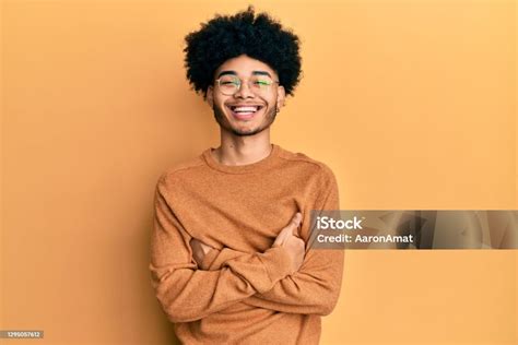 캐주얼 한 겨울 스웨터를 입고 아프로 머리를 가진 젊은 아프리카 계 미국인 남자는 카메라를보고 교차 팔로 미소 행복 얼굴 긍정적 인 사람 남자에 대한 스톡 사진 및 기타
