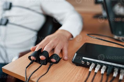 Hand With Electrodes On Fingers Is On The Table Suspicious Man Passes