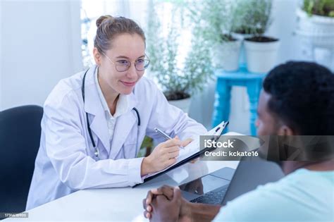 의사는 체크리스트를 들고 병원에서 남자 환자와 이야기합니다 병실에서 남성 환자를 검사하는 의사 20 24세에 대한 스톡 사진 및 기타 이미지 Istock