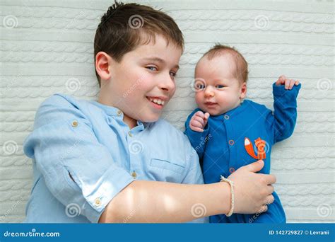 Gro Er Bruder Der Sein Neugeborenes Baby Umarmt Kleinkindkind Das Neue Geschwister Trifft