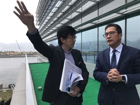 建築署總工程策劃經理李翹彥左向黃偉綸局長介紹外牆安裝的遮陽板是用作減輕熱能走進大樓內