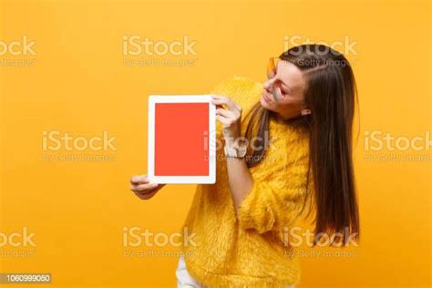 밝은 노란색 배경에 고립 손에 빈 검은색 빈 화면으로 태블릿 Pc 컴퓨터에 보고 심장 안경에 젊은 여자 사람들이 진심으 감정 라이프 스타일 개념 광고 영역입니다 가을에 대한