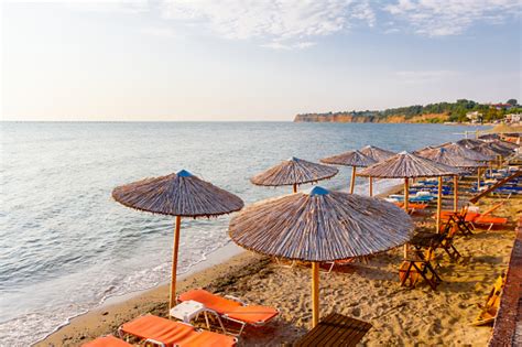 아침 빛 Loungers 자 우산을 통해 물 가장자리를 따라 해안선 옆 배치 됩니다 0명에 대한 스톡 사진 및 기타 이미지