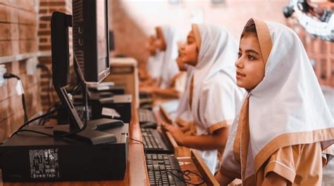 Premium Photo A Girl Sits At A Computer In A Classroom Looking At A Monitor That Saysno More