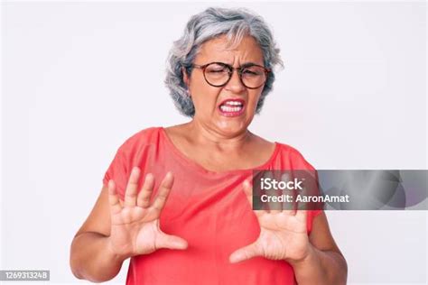 캐주얼한 옷과 안경을 쓰고 있는 히스패닉 회색 머리의 여성은 혐오스러운 반응을 보며 혐오스러운 표정을 짓고 혐오감을 느꼈다 손을 들고 감정에 대한 스톡 사진 및 기타 이미지