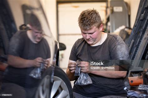 젊은 자동차 정비사는 자동차 수리점에서 고장난 차를 수리합니다 25 29세에 대한 스톡 사진 및 기타 이미지 25 29세