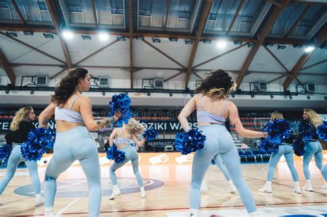 Cheerleaders Performing Dance Routine In Modern Sports Arena With