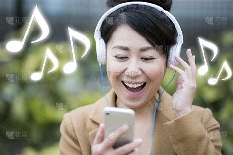 亚洲女性戴着耳机听音乐