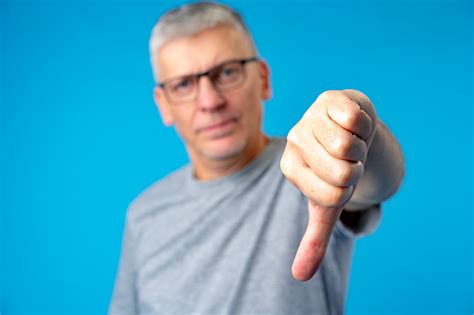 파란 백고룬드에 서있는 엄지 손가락을 보여주는 성숙한 남자의 초상화 1950 1959 년에 대한 스톡 사진 및 기타 이미지 1950 1959 년 개념 결정 Istock