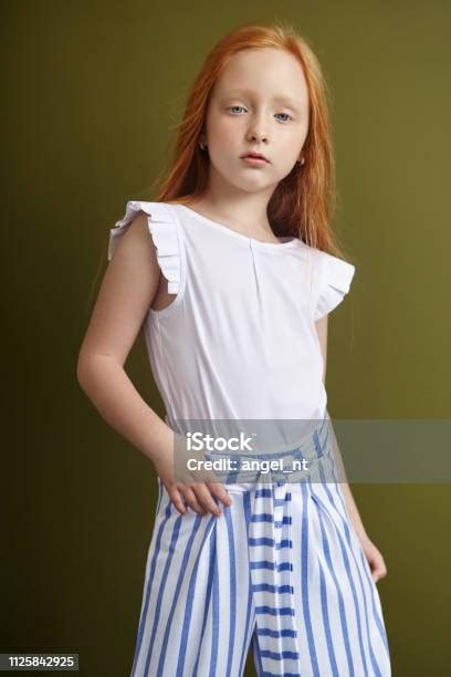 긴 머리와 아름 다운 큰 파란 눈을 가진 아름 다운 빨간 머리 소녀 올리브 색상의 배경에 포즈 여름 옷에 빨간 머리 여자 아이 밝은 붉은 머리를 가진 노르웨이 여자 건강한