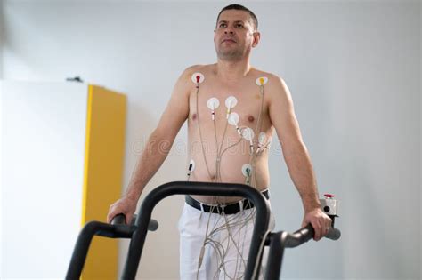 A Middle Aged Man Is Undergoing A Medical Stress Test On A Treadmill Connected To Ecg