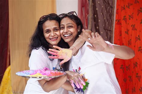 두 명의 쾌활한 인도 여성이 다채로운 손으로 장난스럽게 서서 활기찬 인도 색채 축제인 홀리를 축하합니다 2명에 대한 스톡 사진 및 기타 이미지 Istock