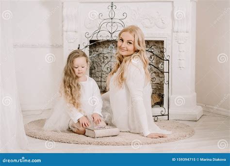 Ώρα για ιστορίες με τη μητέρα και την κόρη μπροστά από το τζάκι Όμορφη οικογένεια με βιβλίο Μαμά