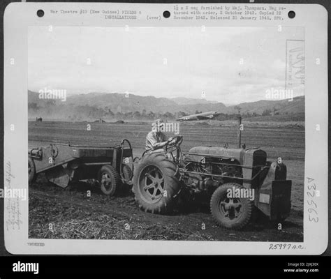 A Tractor Pulling A Carry All Used In The Construction Of An Airfield Somewhere In New Guinea