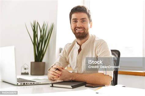 밝은 사무실에 앉아있는 동안 노트북에서 일하는 흰색 셔츠를 입은 유럽 사업가 30 대의 초상화 20 29세에 대한 스톡 사진 및 기타 이미지 Istock