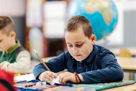 Un Chico Inteligente Resolviendo Problemas De Matemáticas En La Escuela Foto Premium