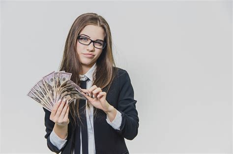 집중 된 젊은 비즈니스 여성은 돈의 더미를 계산 흰색 배경에 고립 소녀는 달러의 둥근에 의해 만족 스 럽 고 혐오와 카메라를 보고 있다 사랑 스러운 사업가는 달러를 계산