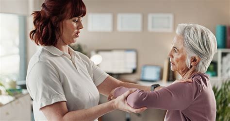 Physio 팔 및 스트레칭을 가진 클리닉에서 지원 환자 및 재활을 가진 고위 여성 물리 치료 관절염 치료 및 관절 검사를 통한 의사의 도움 및 치유 평가 부상에 대한 스톡