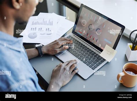High Angle View At Young Data Analyst Using Computer With Charts On