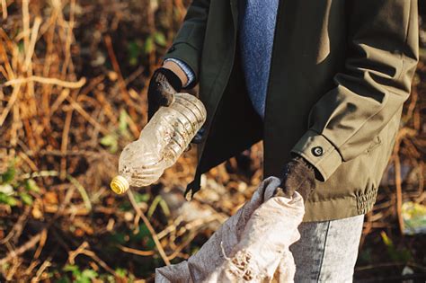공원에서 더러운 플라스틱 병을 줍는 자원 봉사자 여자 손 장갑에 쓰레기를 따기 가방에 쓰레기를 수집 일회용 플라스틱으로 자연 을