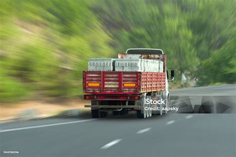 트레일러와 건축 자재 인 폼 블록이 적재 된 트럭은 속도 모션 블러 효과가있는 숲 한가운데있는 고속도로를 따라 운전합니다 트럭에 대한 스톡 사진 및 기타 이미지 Istock